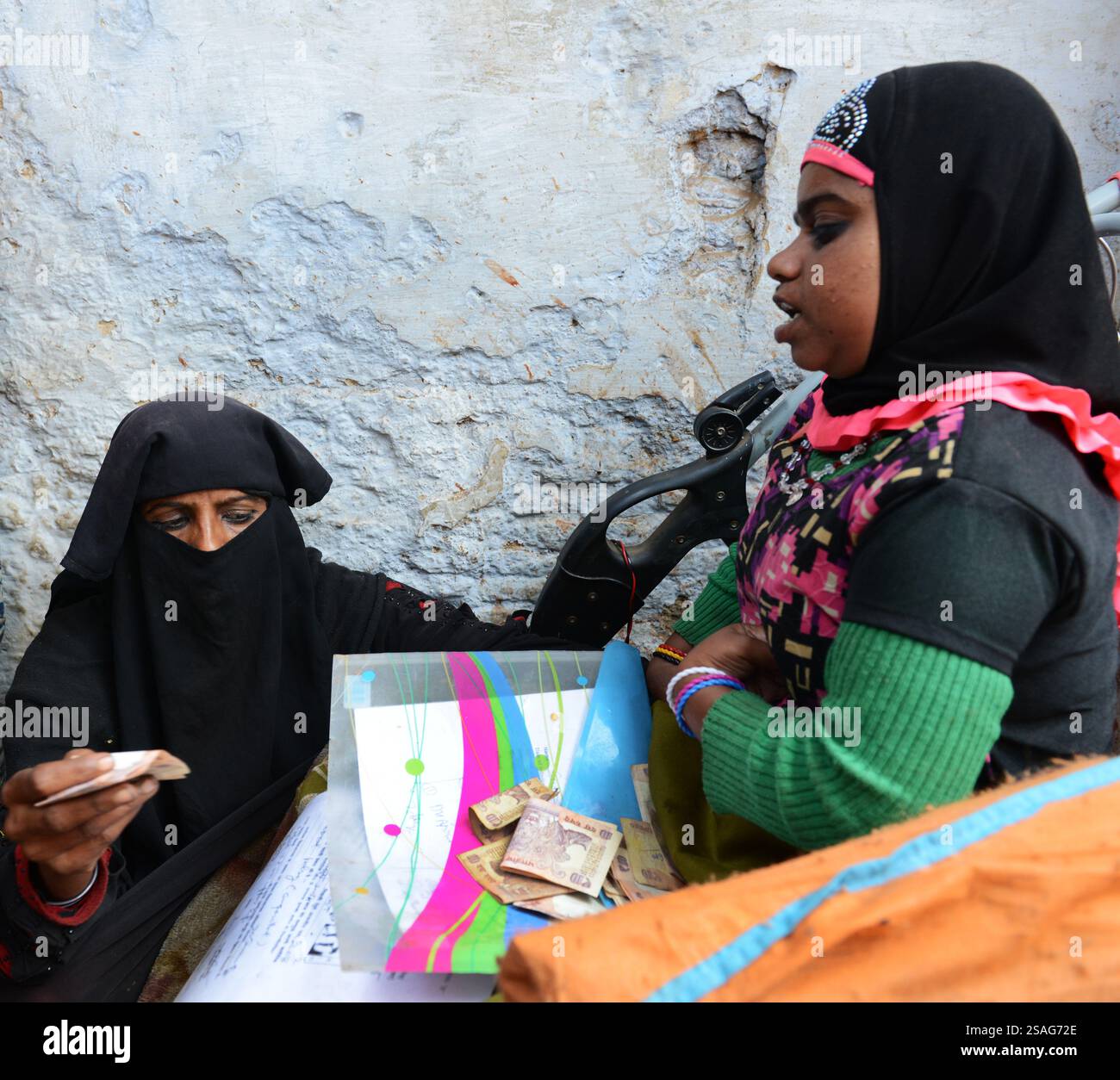 A Muslim woman begging for money and help with her handicapped girl at ...