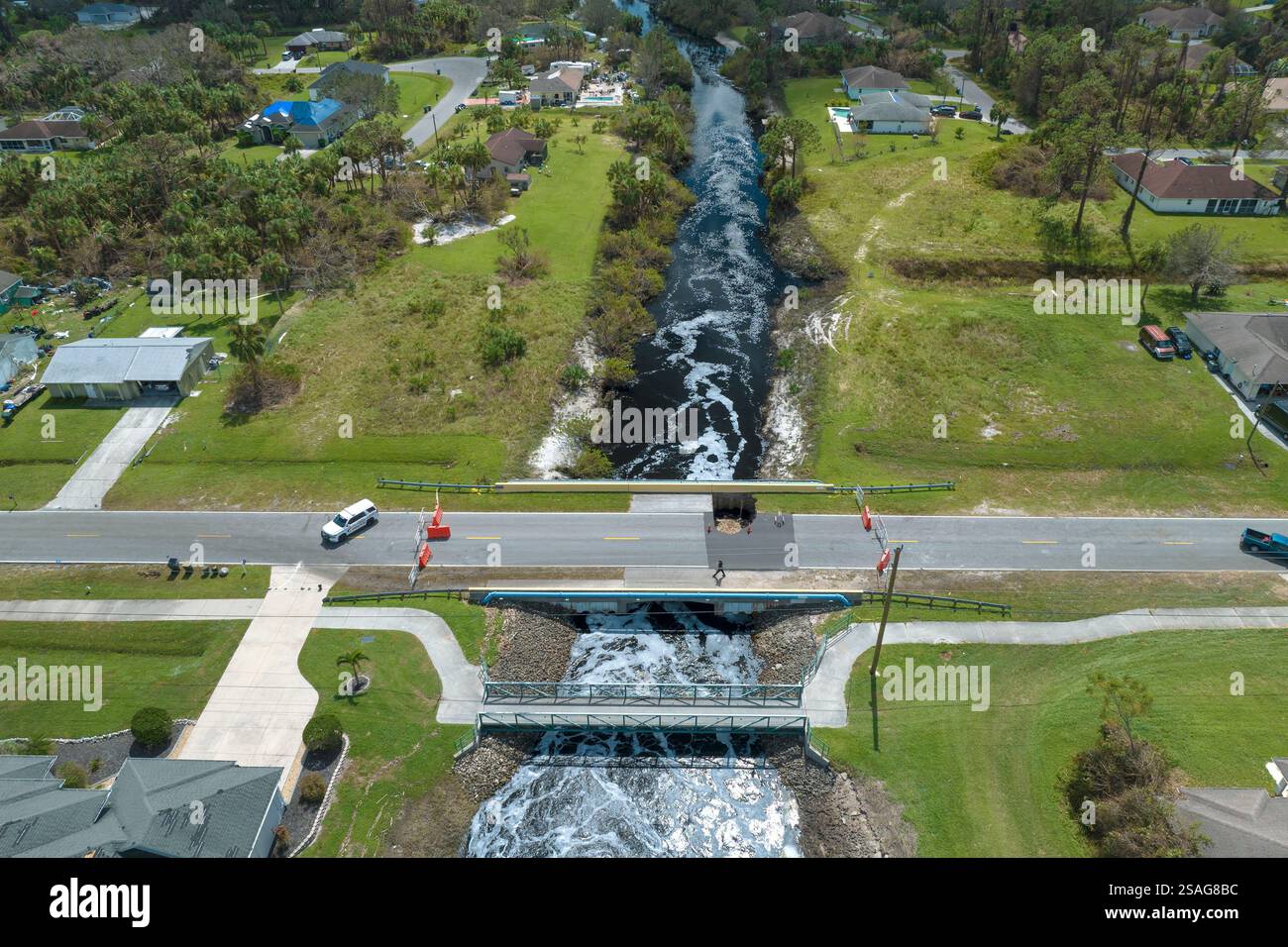 Police car blocking road access at destroyed bridge after hurricane ...