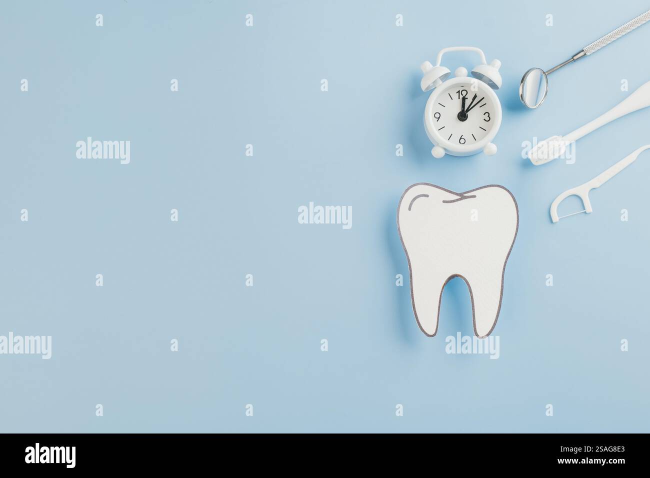 Dentist Day reminder. A paper tooth, white clock, and dental tools on a ...