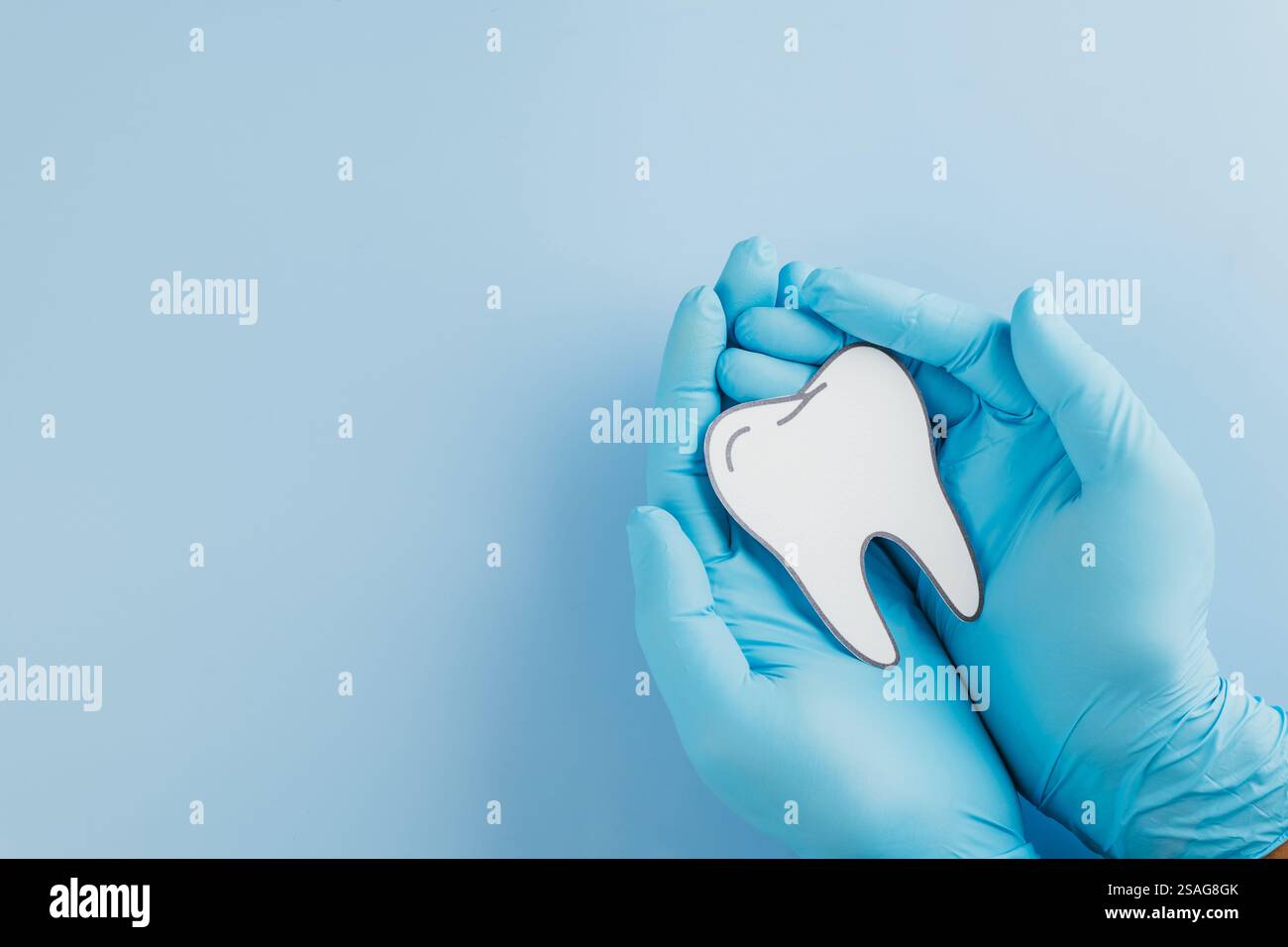Dentist Day, a dentist gloved hands gently hold a tooth paper cutout ...