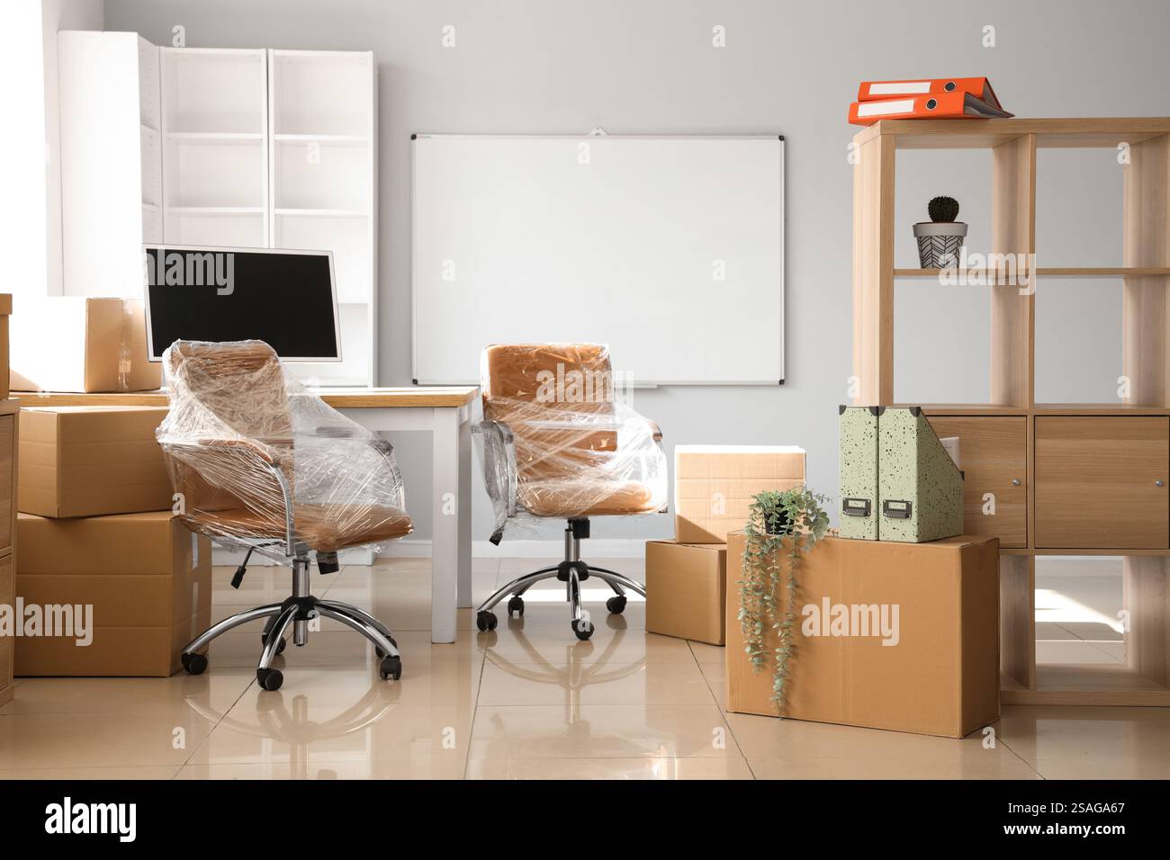 Interior of office with chairs wrapped in stretch film and cardboard ...