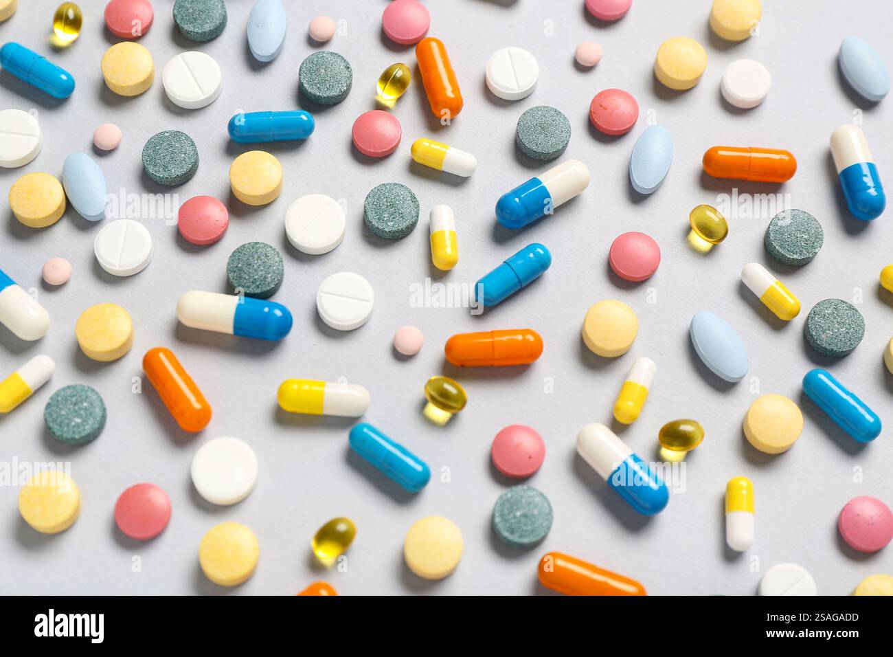 Different colorful pills on grey background Stock Photo - Alamy