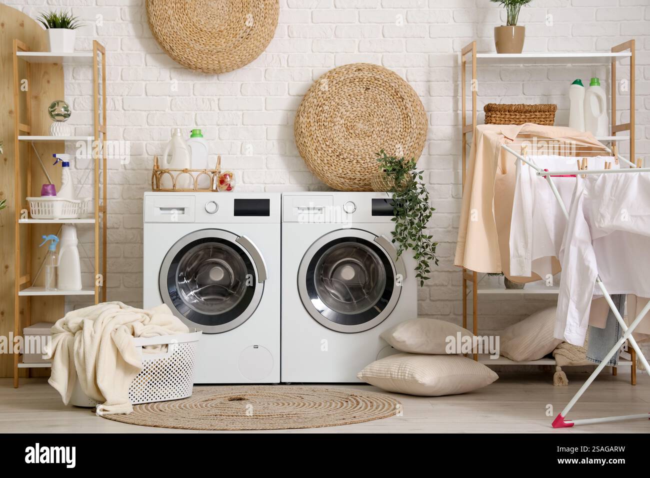 Interior of laundry room with washing machines and clean clothes on ...