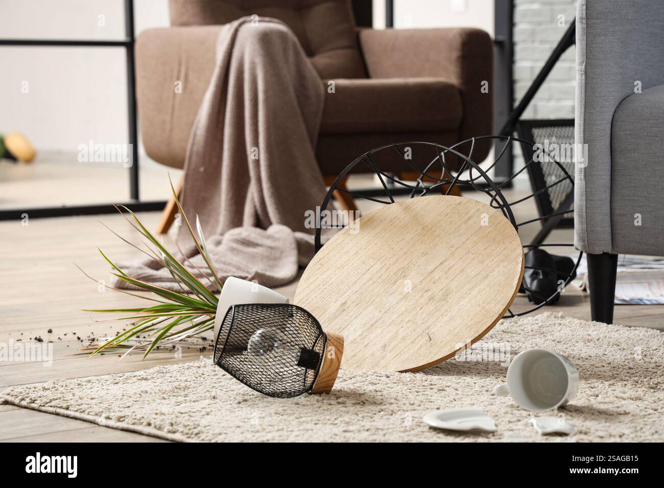 Overturned table with lamp and plant on carpet in messy room Stock ...