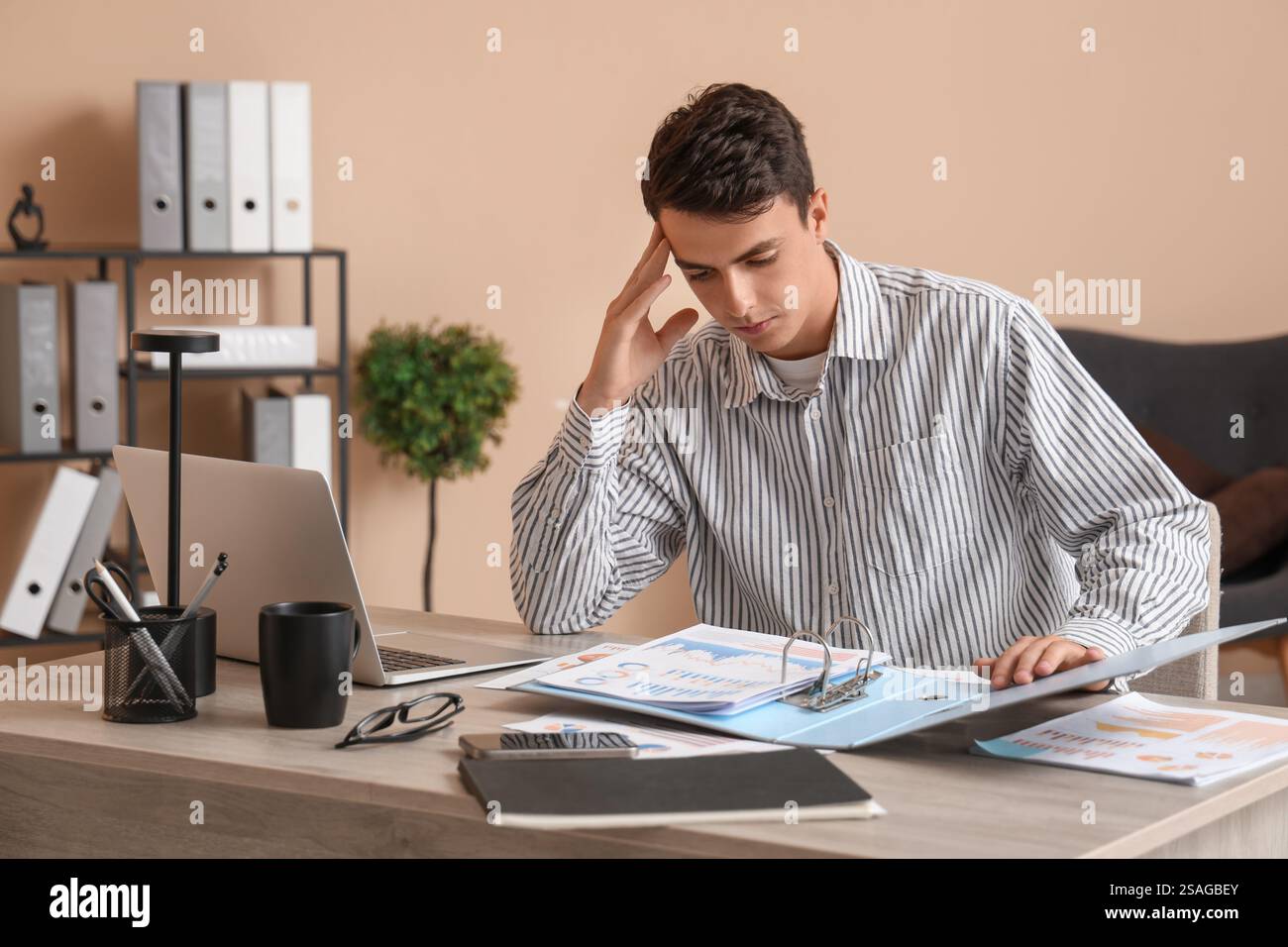 Male economist working with diagrams in office Stock Photo - Alamy