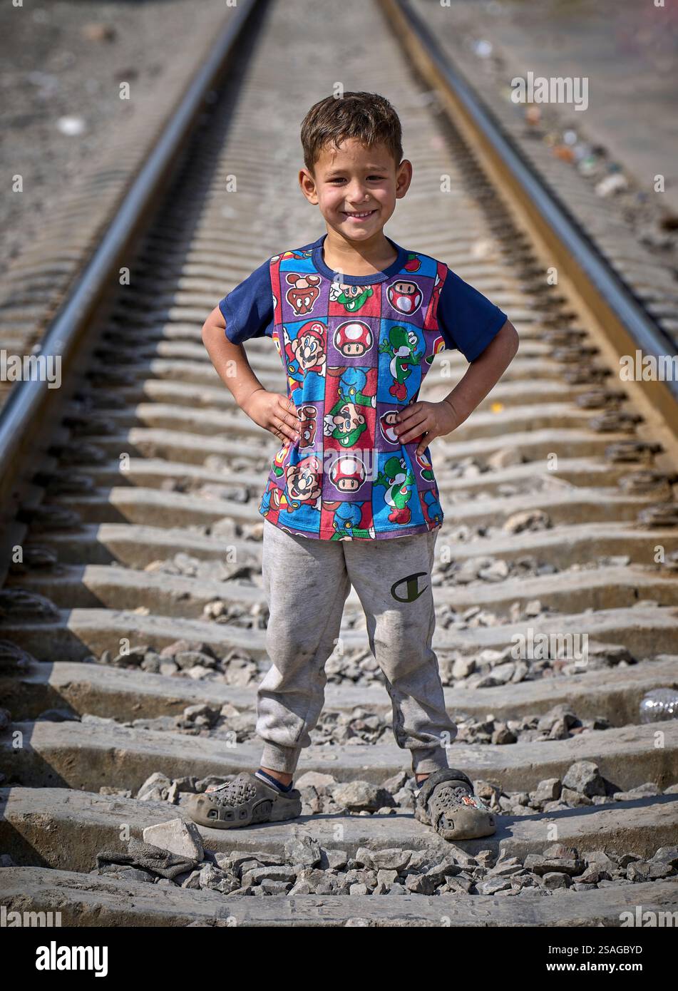 Sebastian, a 5-year old Venezuelan boy, poses amid the railroad tracks ...