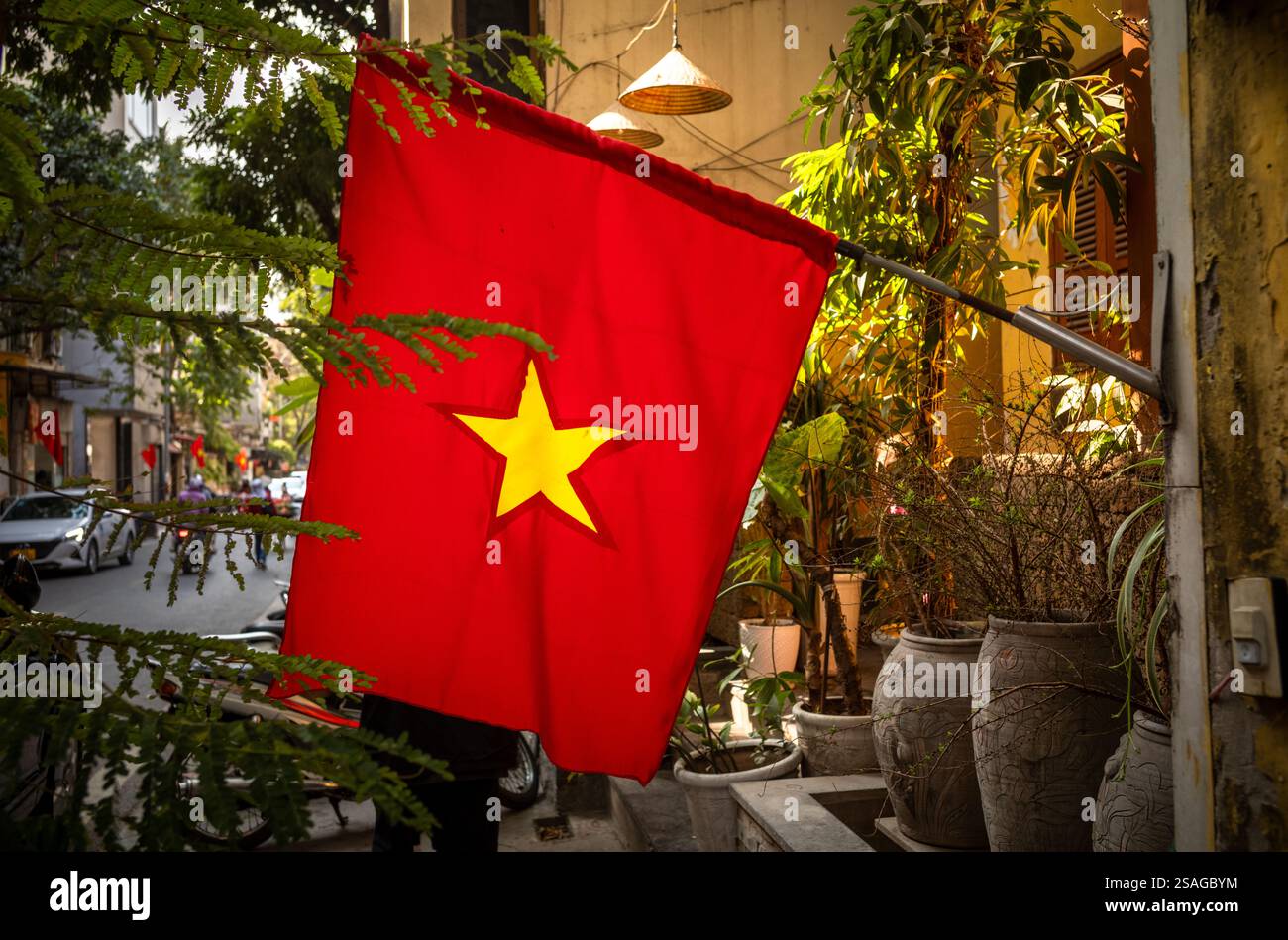 A red and yellow-starred Vietnamese flag hanging outside a house in ...