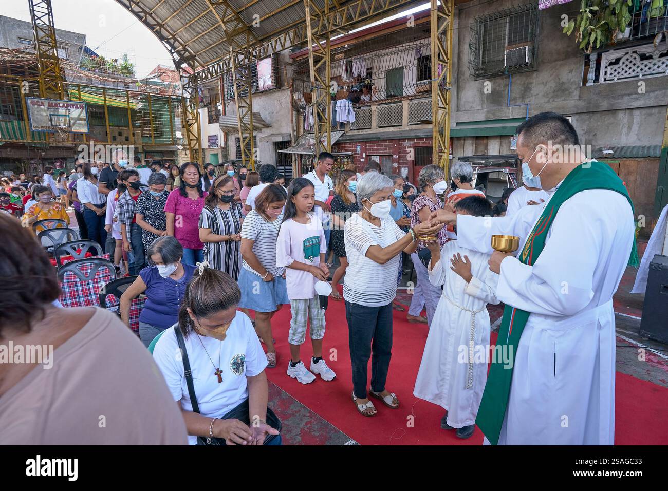 Father Leo Pepito celebrates Catholic Mass in the basketball court of a ...