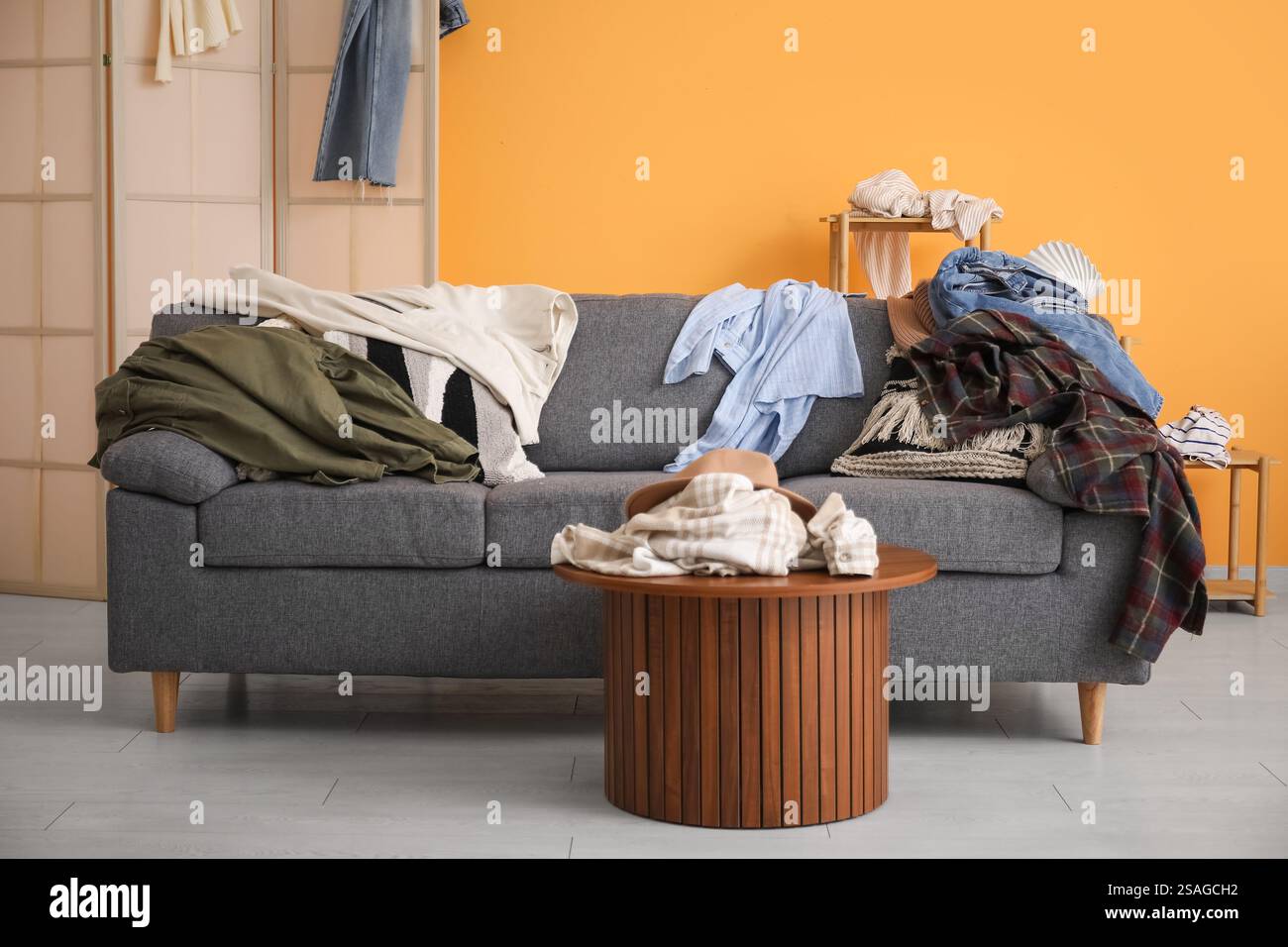 Interior of messy living room with coffee table, folding screen and ...