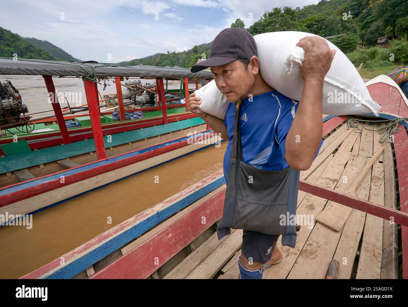 Workers load bags of rice on to boats in Mae Sam Laep, a Thai village ...