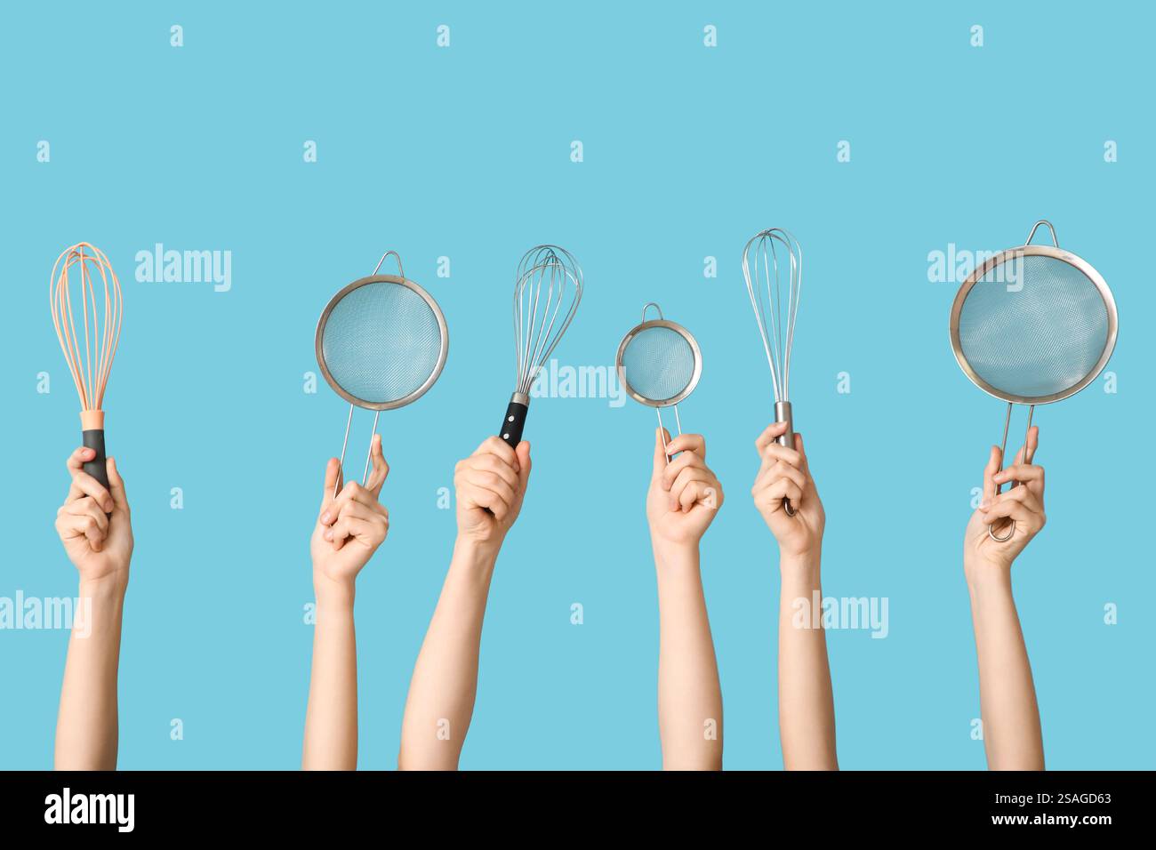 Female hands with sieves and whisks on blue background Stock Photo - Alamy