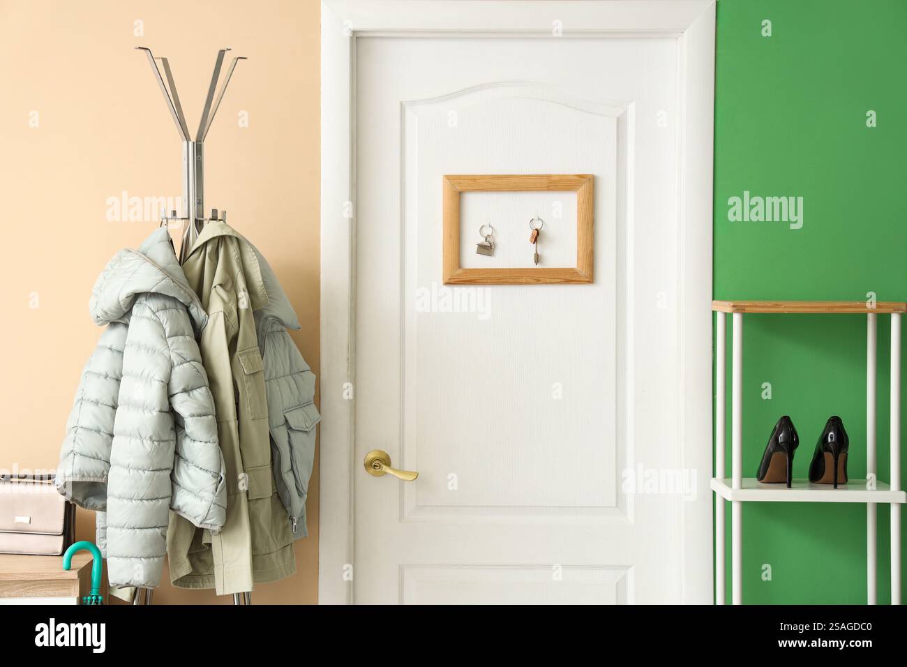 Interior of stylish hall with clothes rack, shoes stand and keys ...