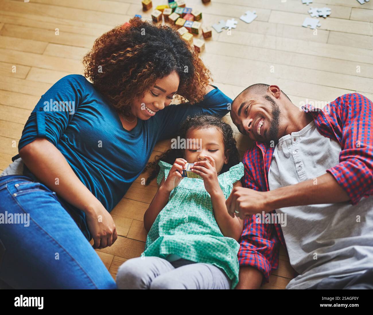 Happy, relax and child with parents on floor in home for bonding, love ...