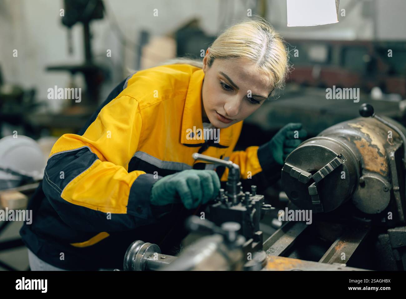 caucasian women worker working in heavy metal industry factory with steel part lathe machine ...