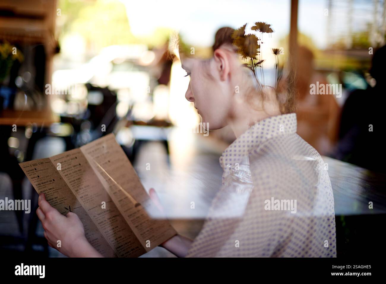 Woman, window and reading menu at restaurant, hospitality service and ...