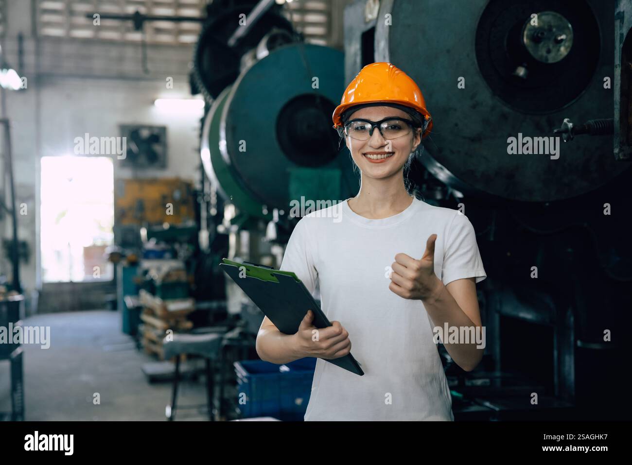 portrait professional women worker in heavy metal industry factory thumbs up good welfare ...