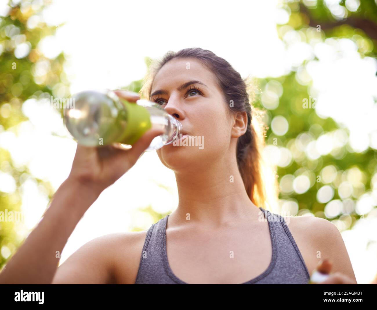 Athlete, fitness and woman drinking water in nature for marathon ...