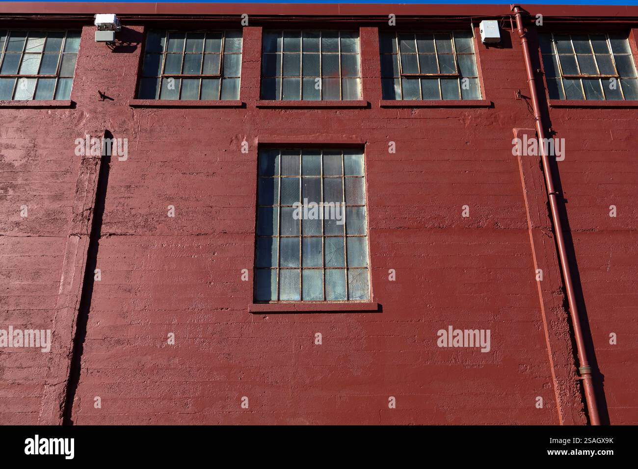 Old warehouse windows, some broken, on the Pacific National Exhibition grounds in Vancouver, BC ...