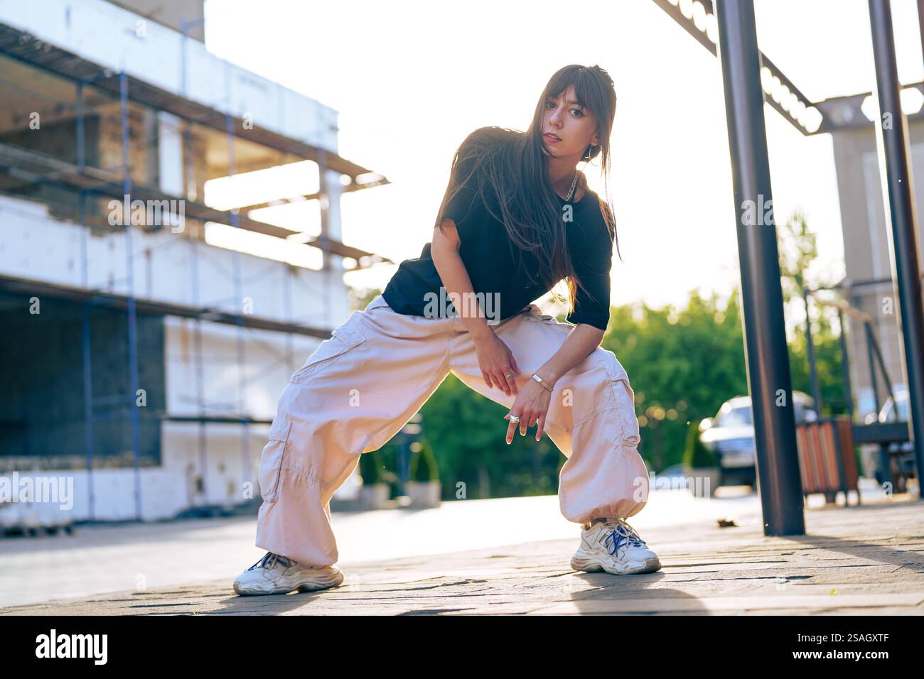 Young woman performing an urban dance routine in casual attire at a ...