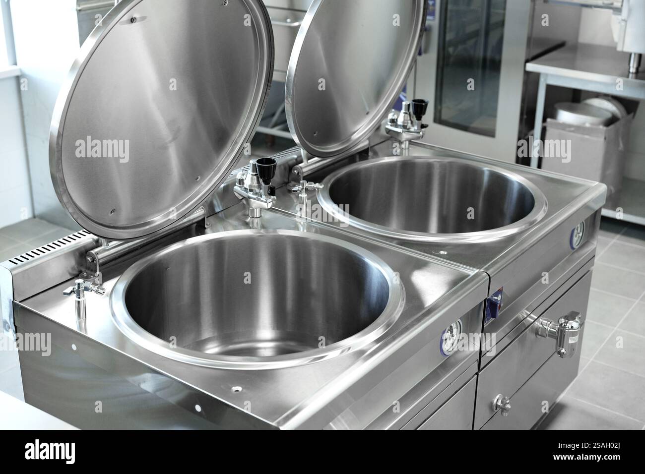 Stainless steel cooking equipment in a modern kitchen with dual ...