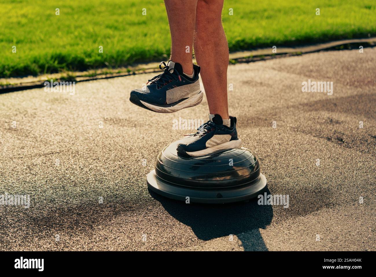 Balance training on a stability disc during an outdoor exercise session ...