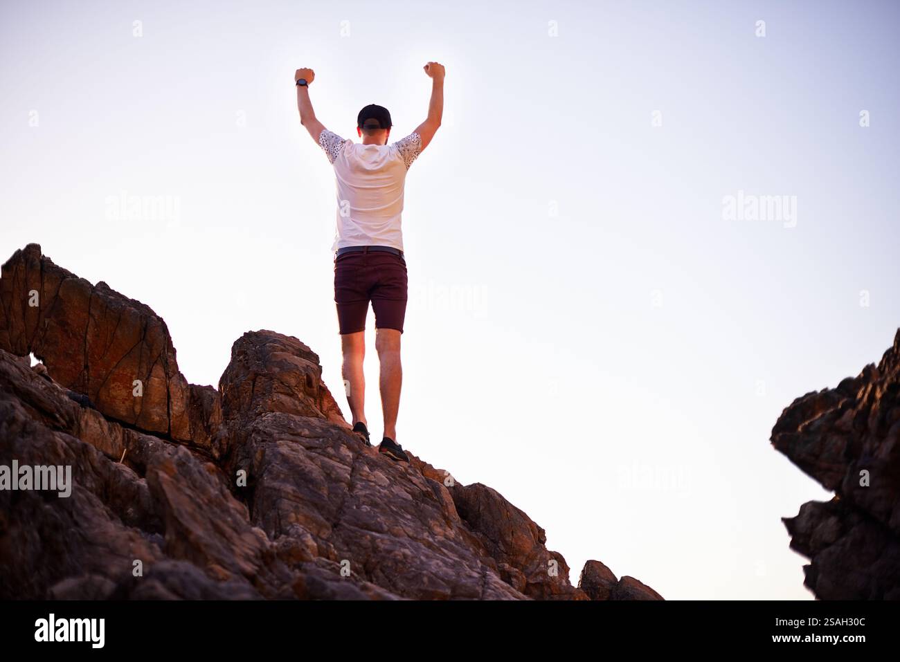 Celebration, rock climber and man on mountain, back and achievement for ...