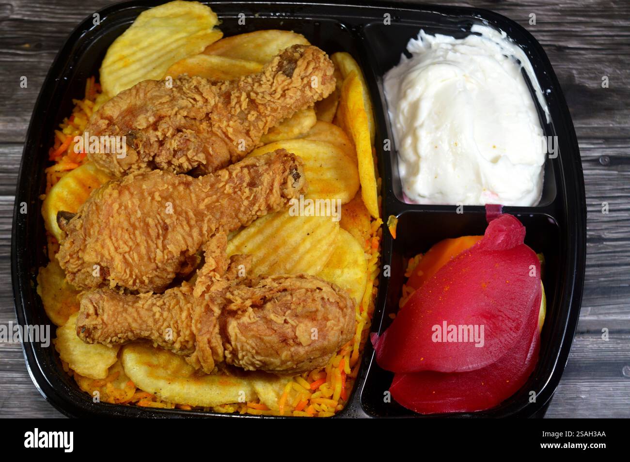 Broasted chicken meal with colorful Basmati rice, pickled slices of ...