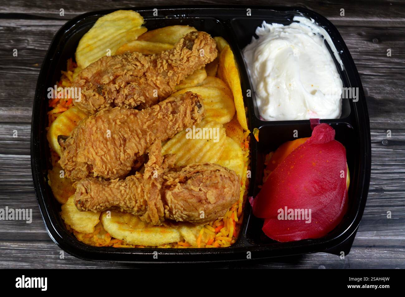 Broasted chicken meal with colorful Basmati rice, pickled slices of ...