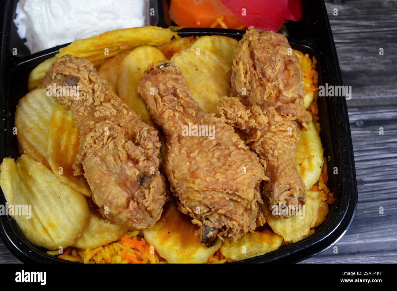 Broasted chicken meal with colorful Basmati rice, pickled slices of ...