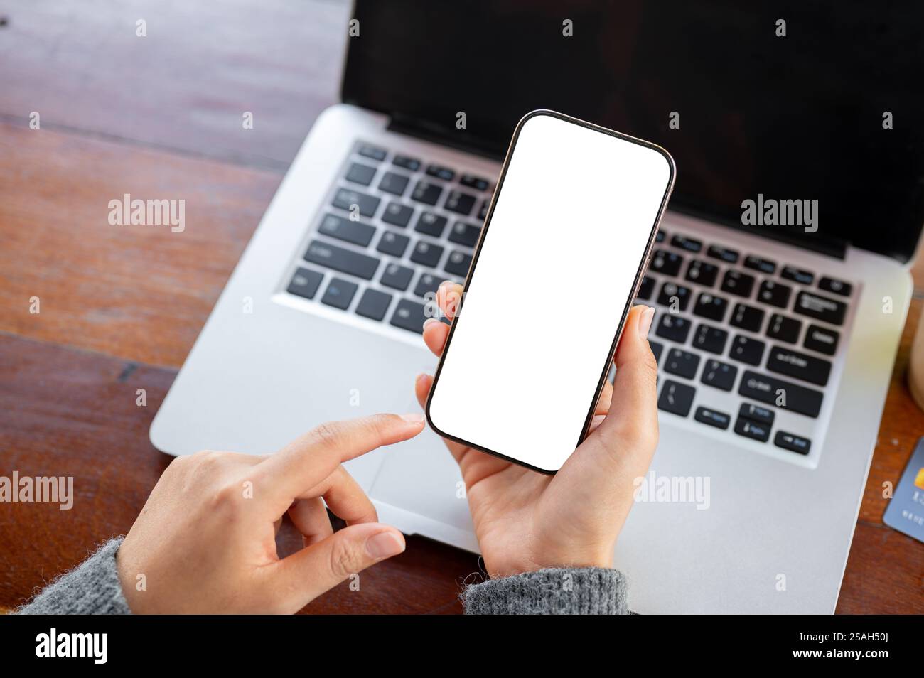 A top view of a woman pointing at a smartphone screen in her hand ...