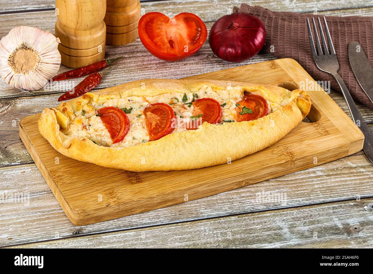 Turkish homemade Pide with cheese and tomato Stock Photo - Alamy