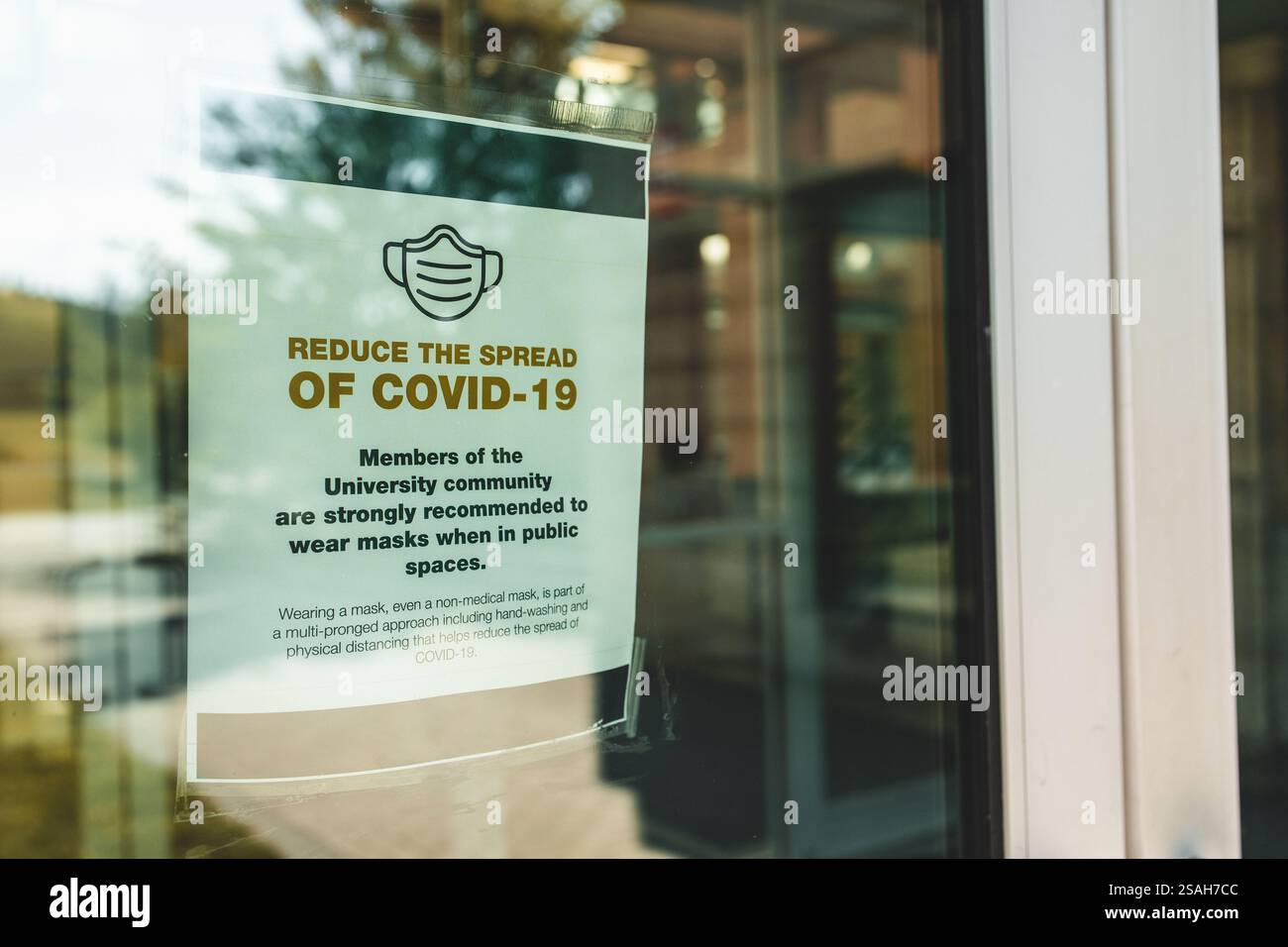 COVID-19 safety notice at university entrance recommending mask wearing ...