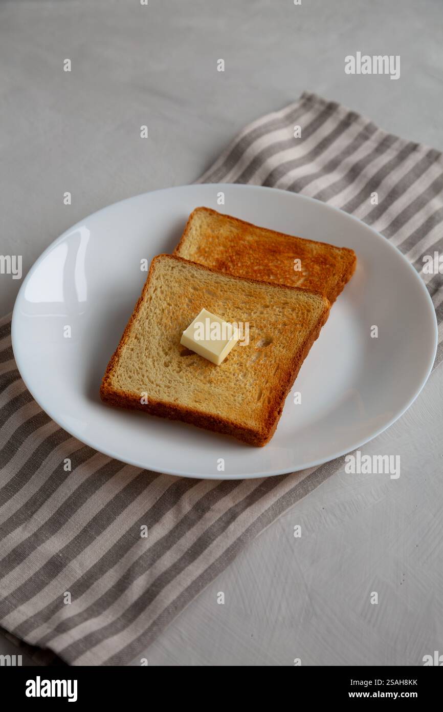 Homemade Toasted Bread Slice with Butter on a Plate, side view Stock ...