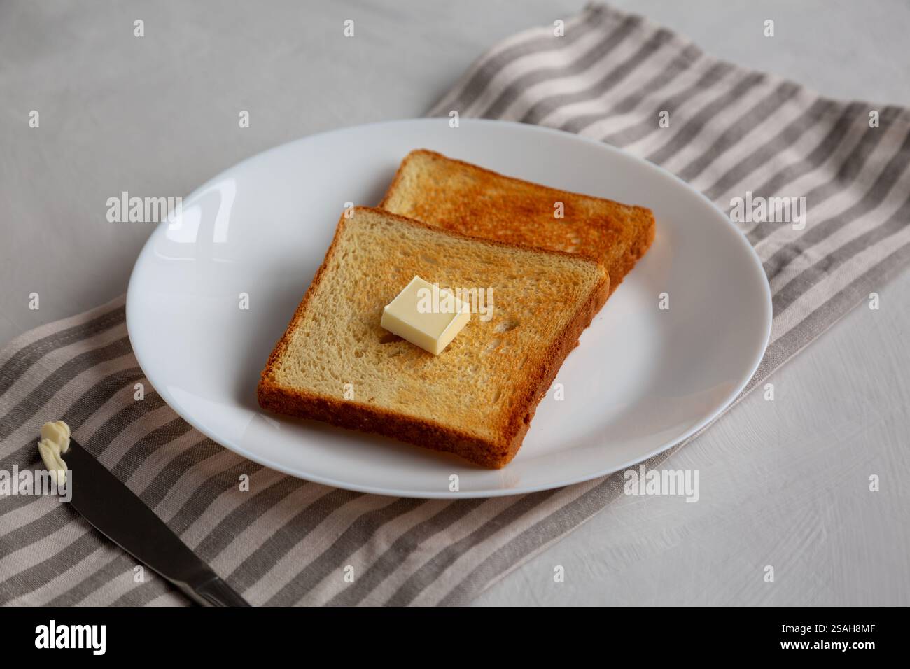 Homemade Toasted Bread Slice with Butter on a Plate, side view Stock ...