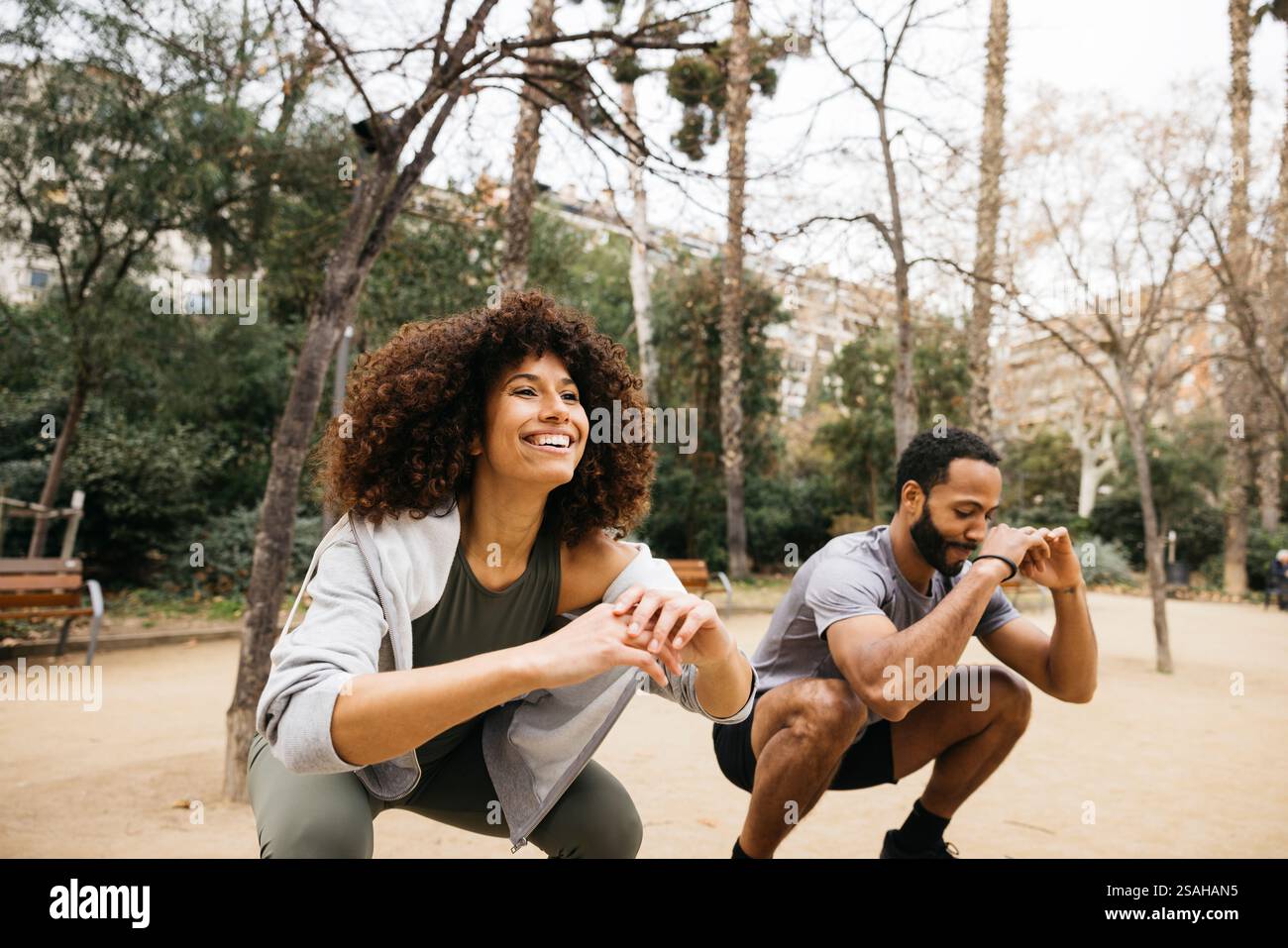 A trainer coaches a student outdoors during a fitness session, focusing ...