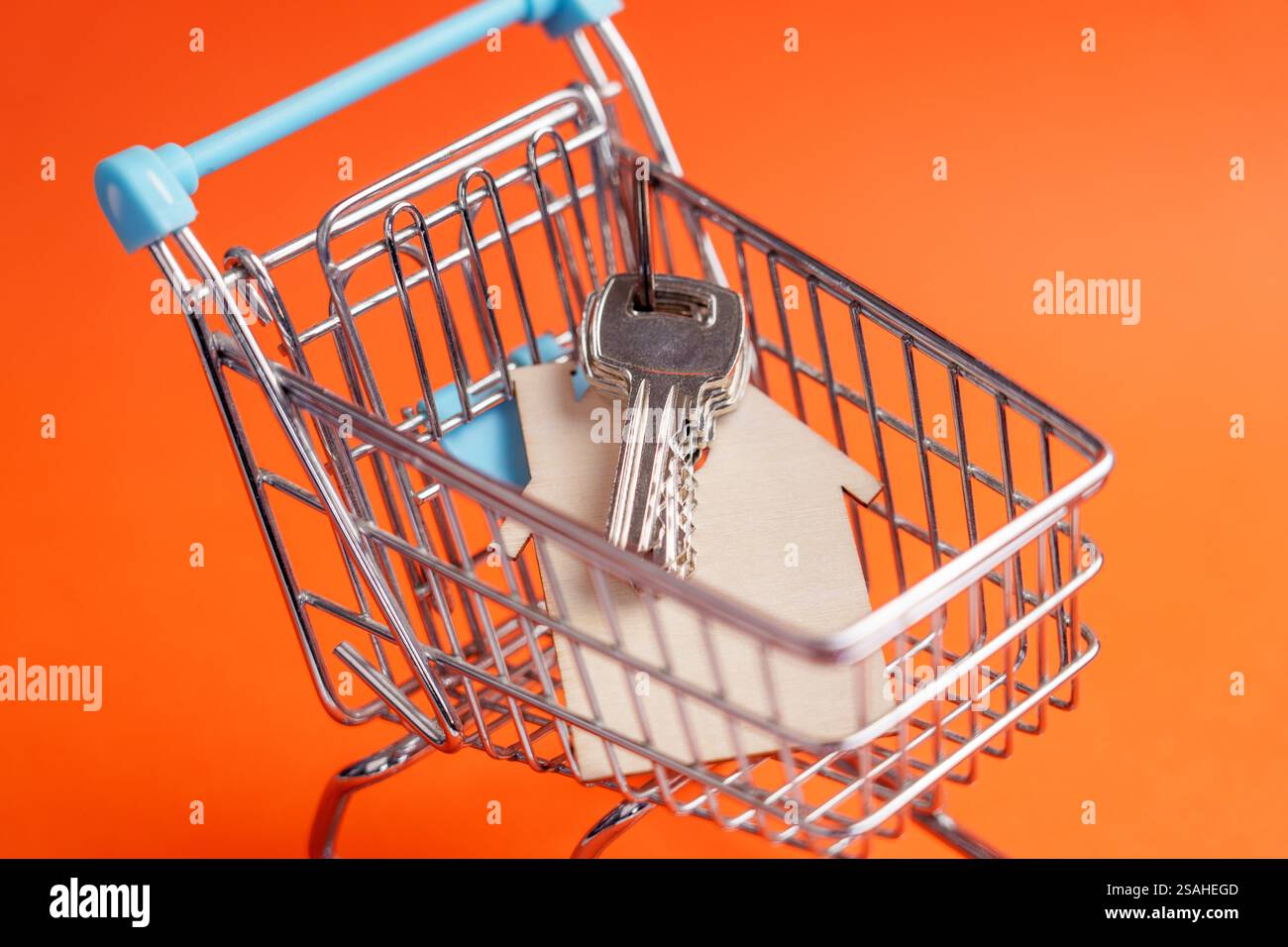 Home keys in small shopping cart. Bright creative orange color ...