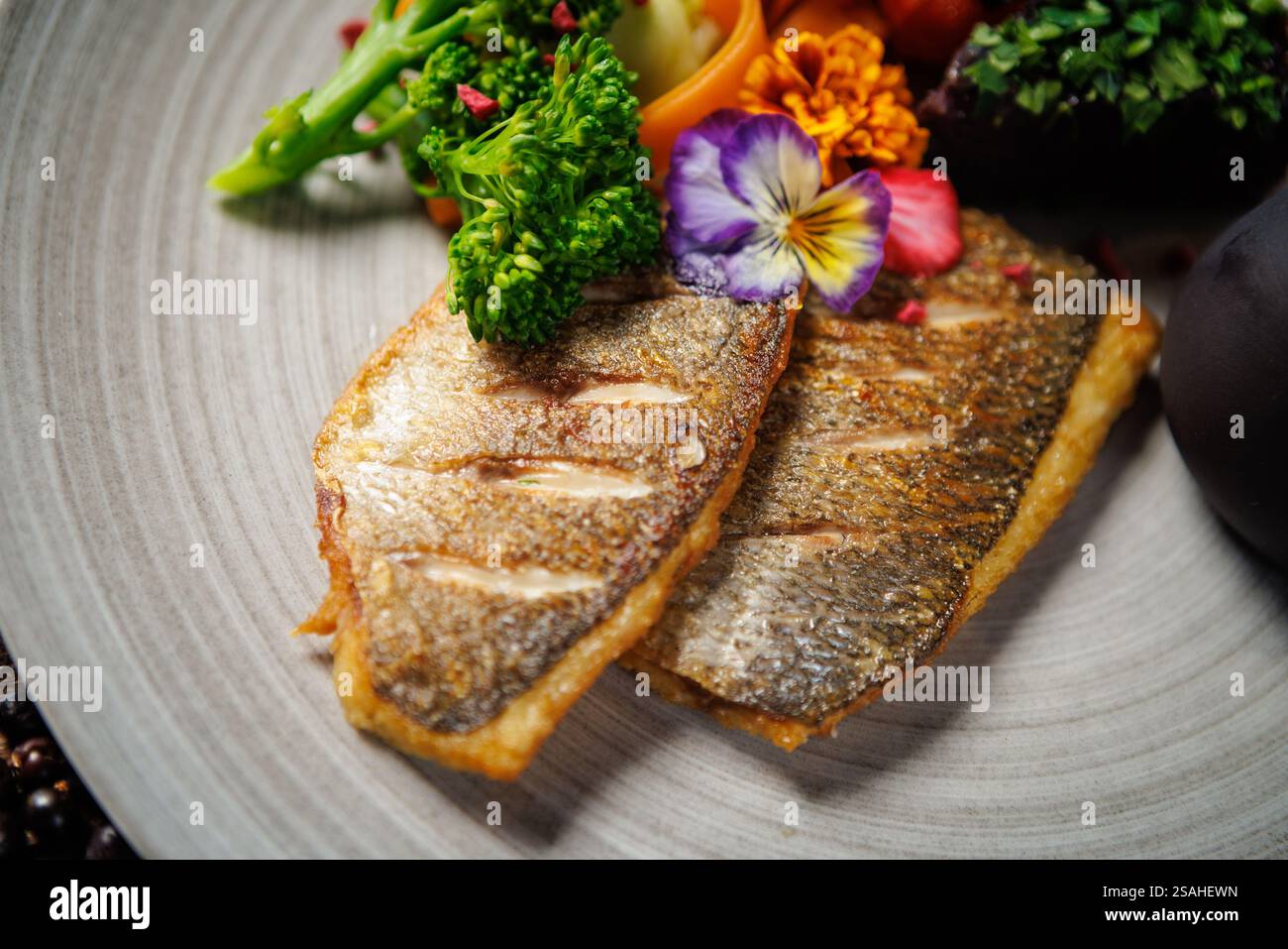 Pan-seared fish fillet with vibrant vegetables, including broccoli ...
