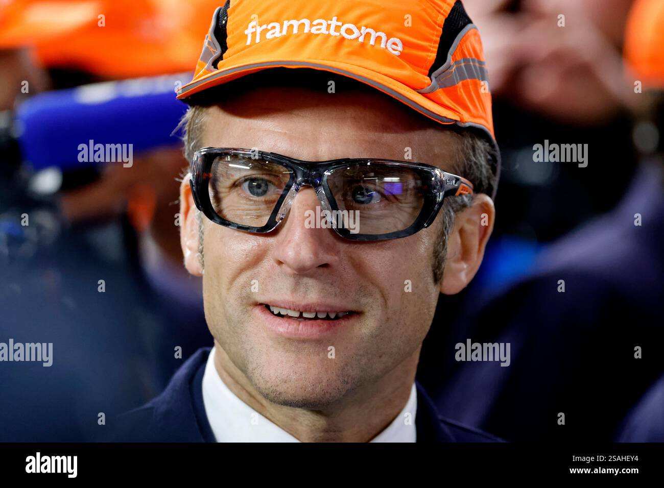 French President Emmanuel Macron looks on as he wears protective ...