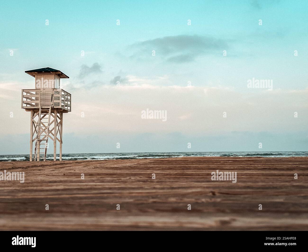 A white wooden lifeguard watchtower located on the beach. A rescue ...