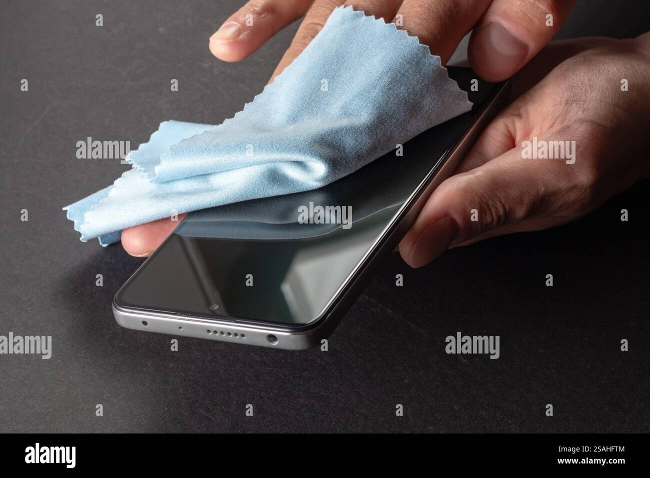 Germs elimination. Cleaning the smartphone screen with a fiber cloth ...