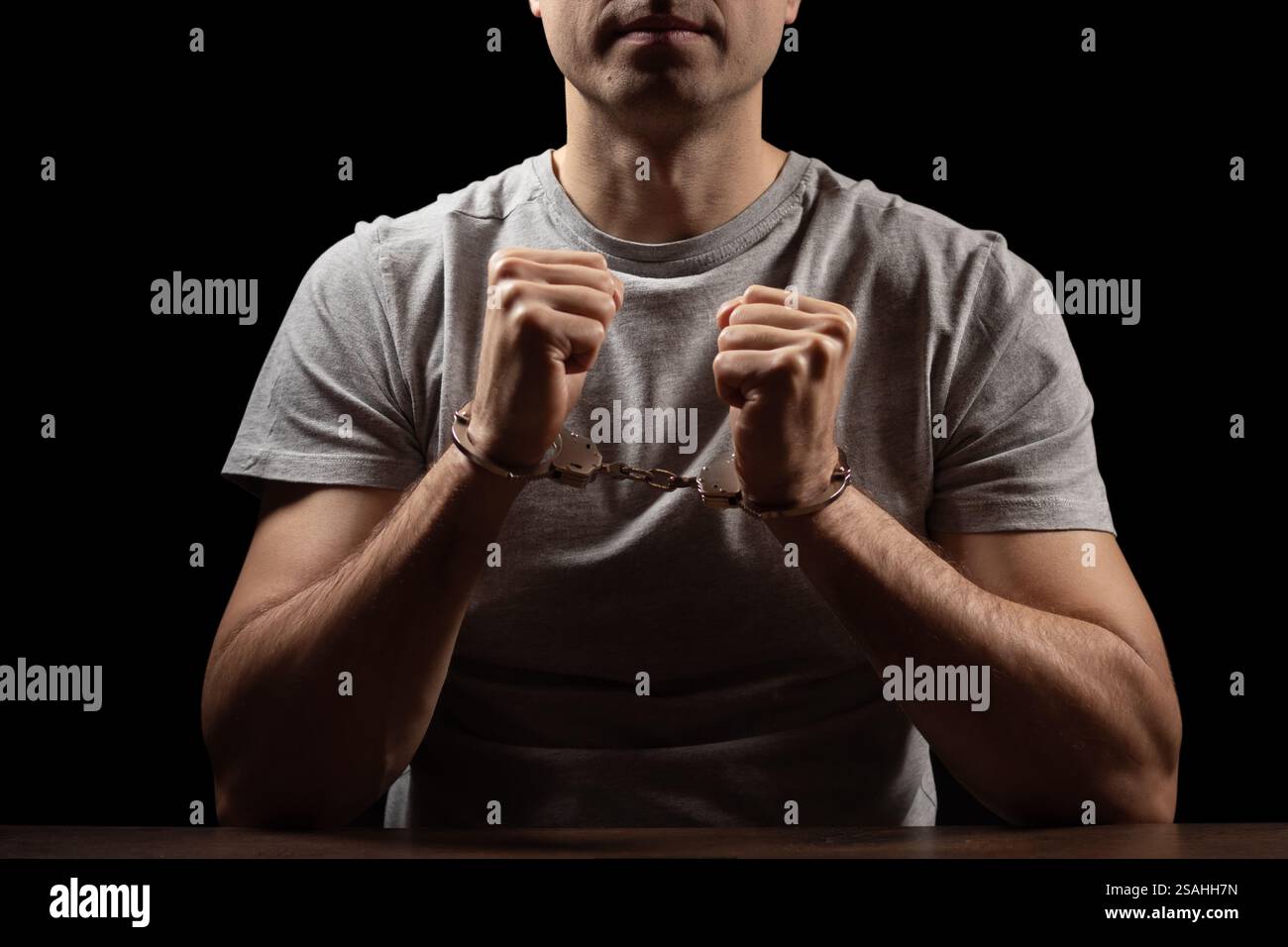 The arrested criminal handcuffed. Hands with handcuffs in the front ...