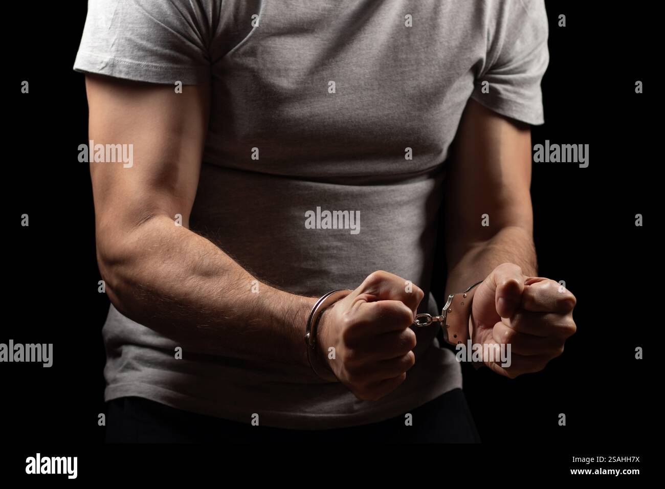 The arrested criminal handcuffed. Hands with handcuffs in the front ...