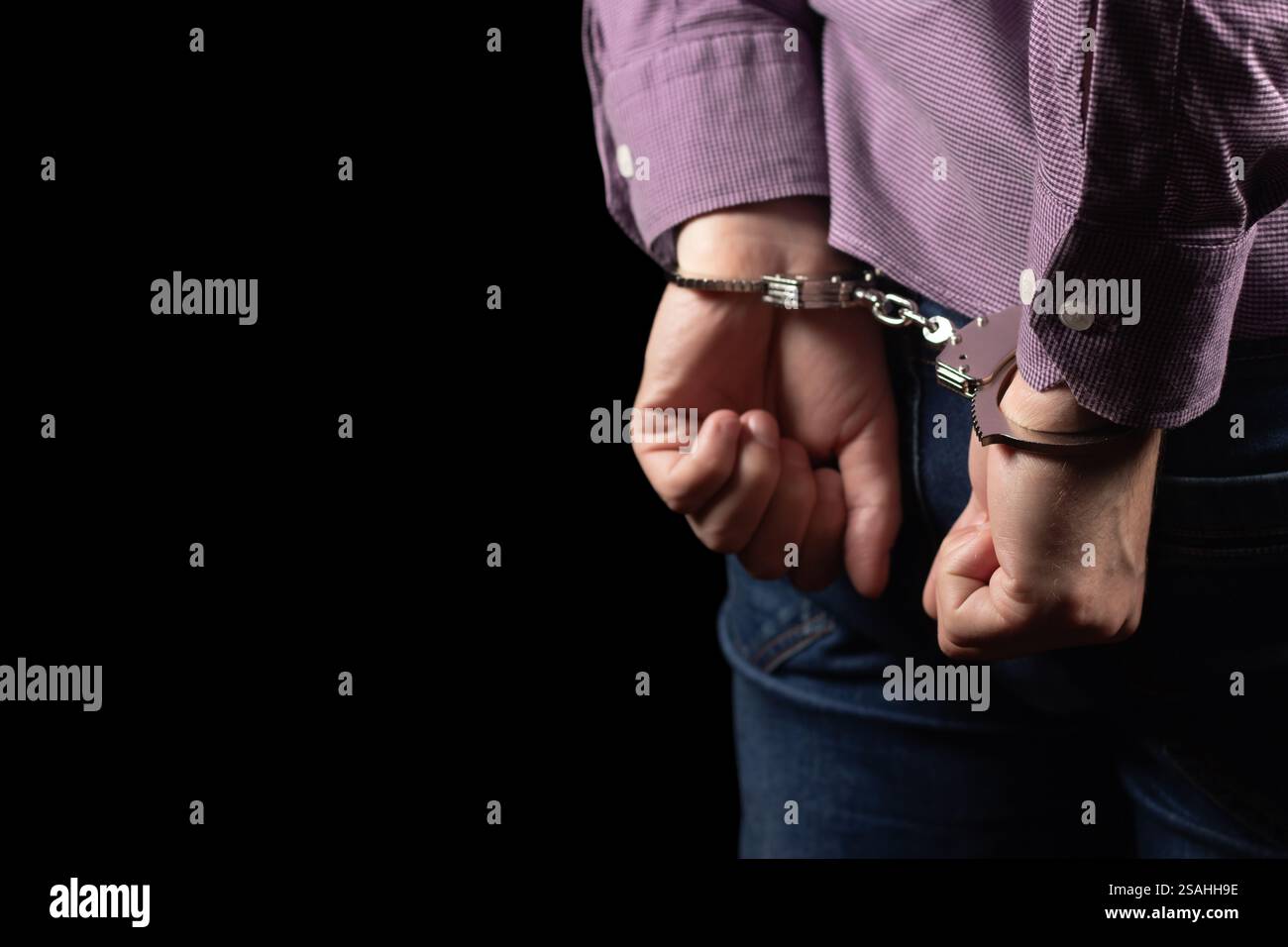 Arrested man in handcuffs with handcuffed hands behind back in prison ...