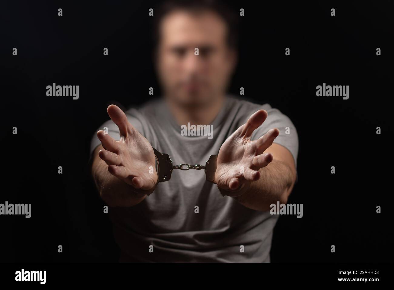 The arrested criminal handcuffed. Hands with handcuffs in the front ...