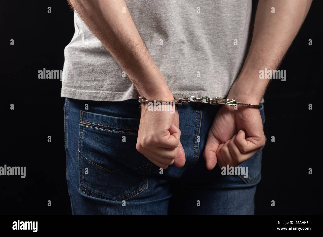 Arrested man in handcuffs with handcuffed hands behind back in prison ...