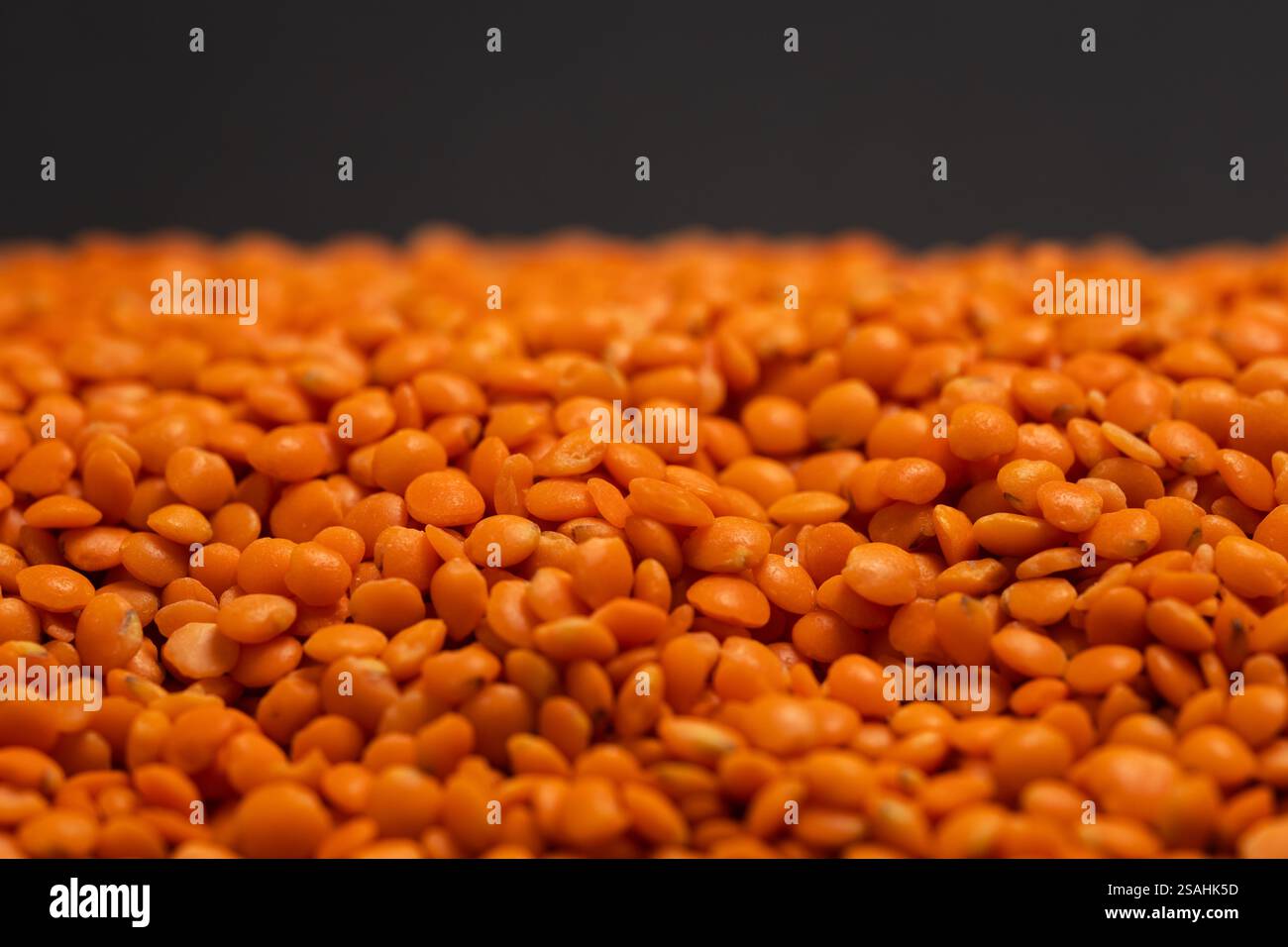 Pile of red lentils on dark background. Dry grains of red lentils ...