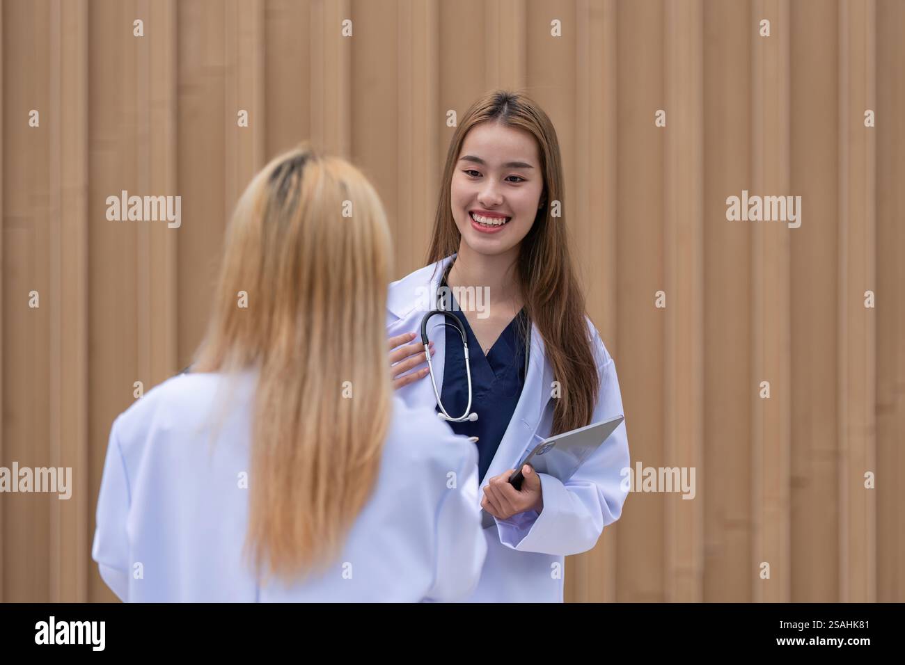 Diverse female doctors consulting outdoors in a professional setting ...