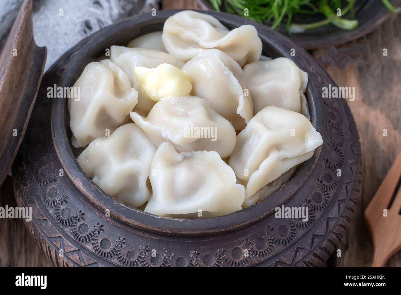 Siberian dumplings boiled with butter. Dumplings in traditional clay ...