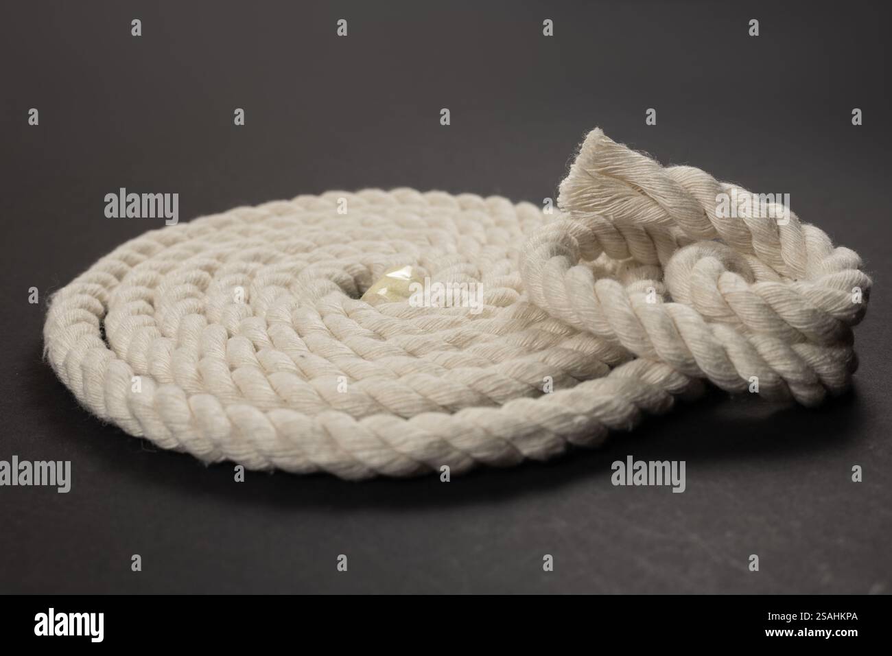 Coiled rope over a dark background Stock Photo - Alamy