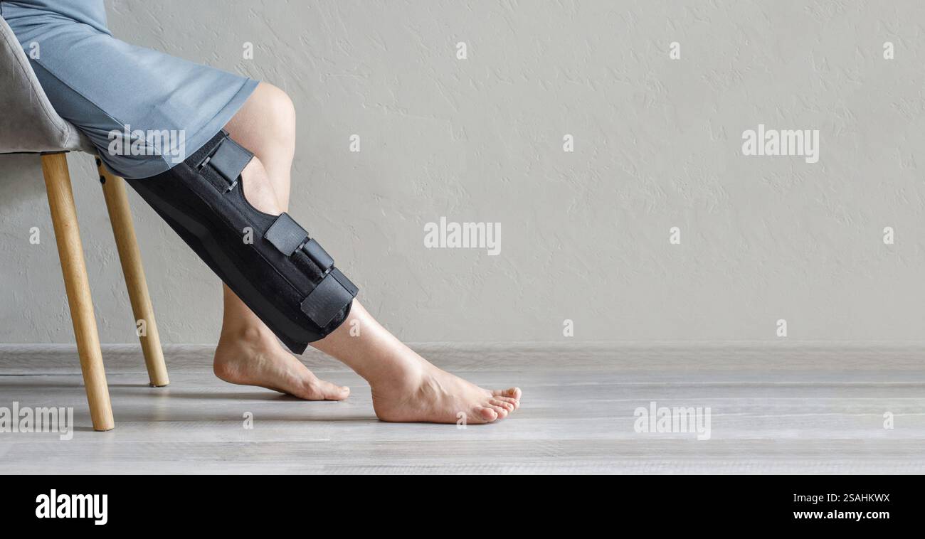 Knee brace on woman leg on grey background with copy space. Injury ...